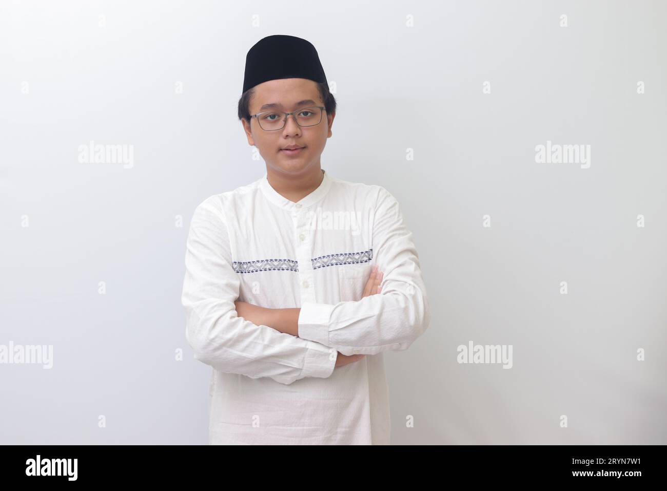 Portrait of young Asian muslim man standing with crossed arms and ...