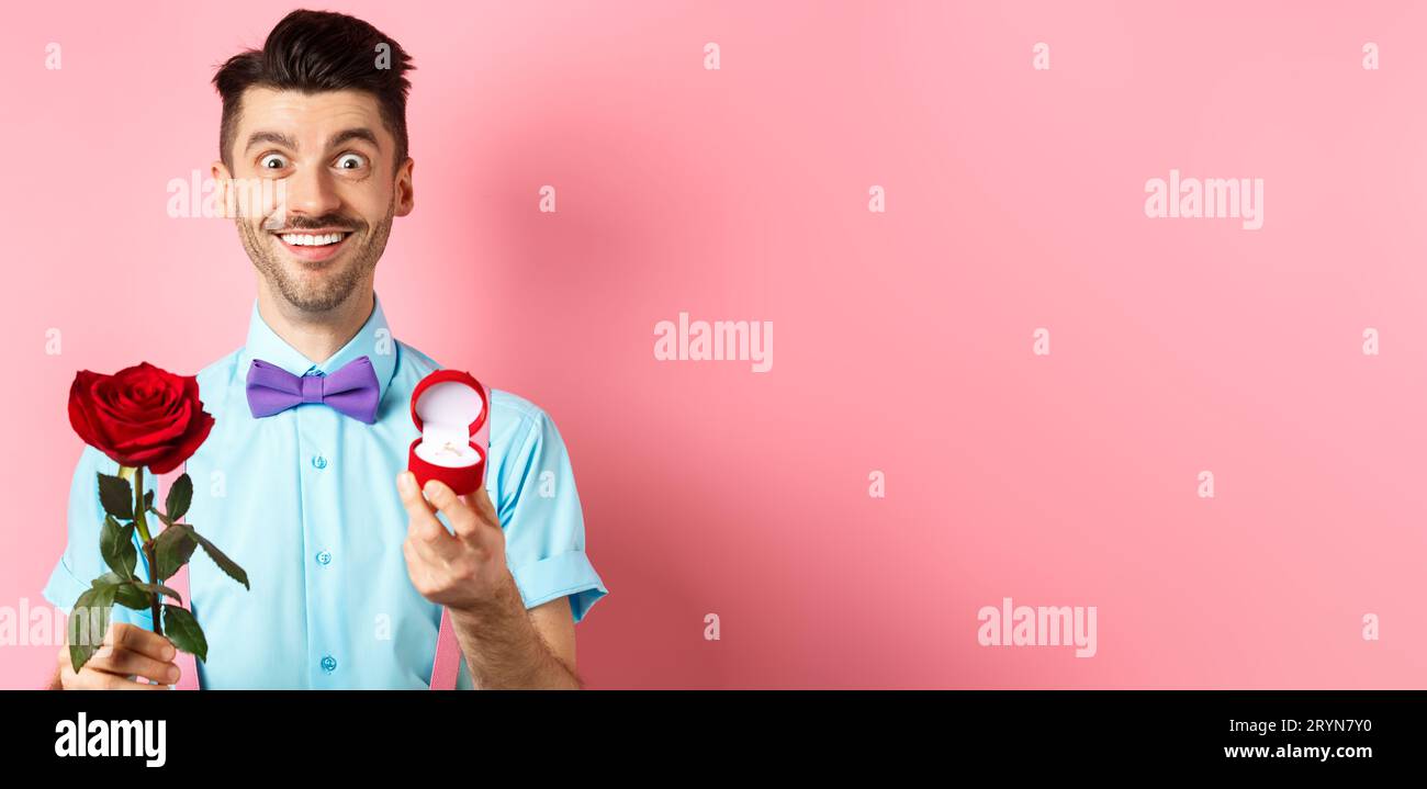 Valentines day. Smiling handsome man asking to marry him, showing ...