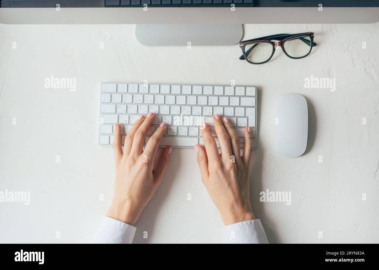 Minimalistic workspace with a computer keyboard. Hands typing on ...