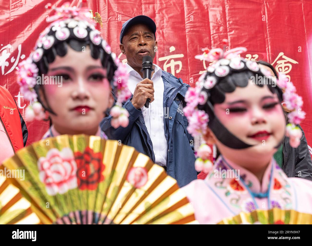 Mayor Eric Adams delivers remarks as young girls in traditional ...