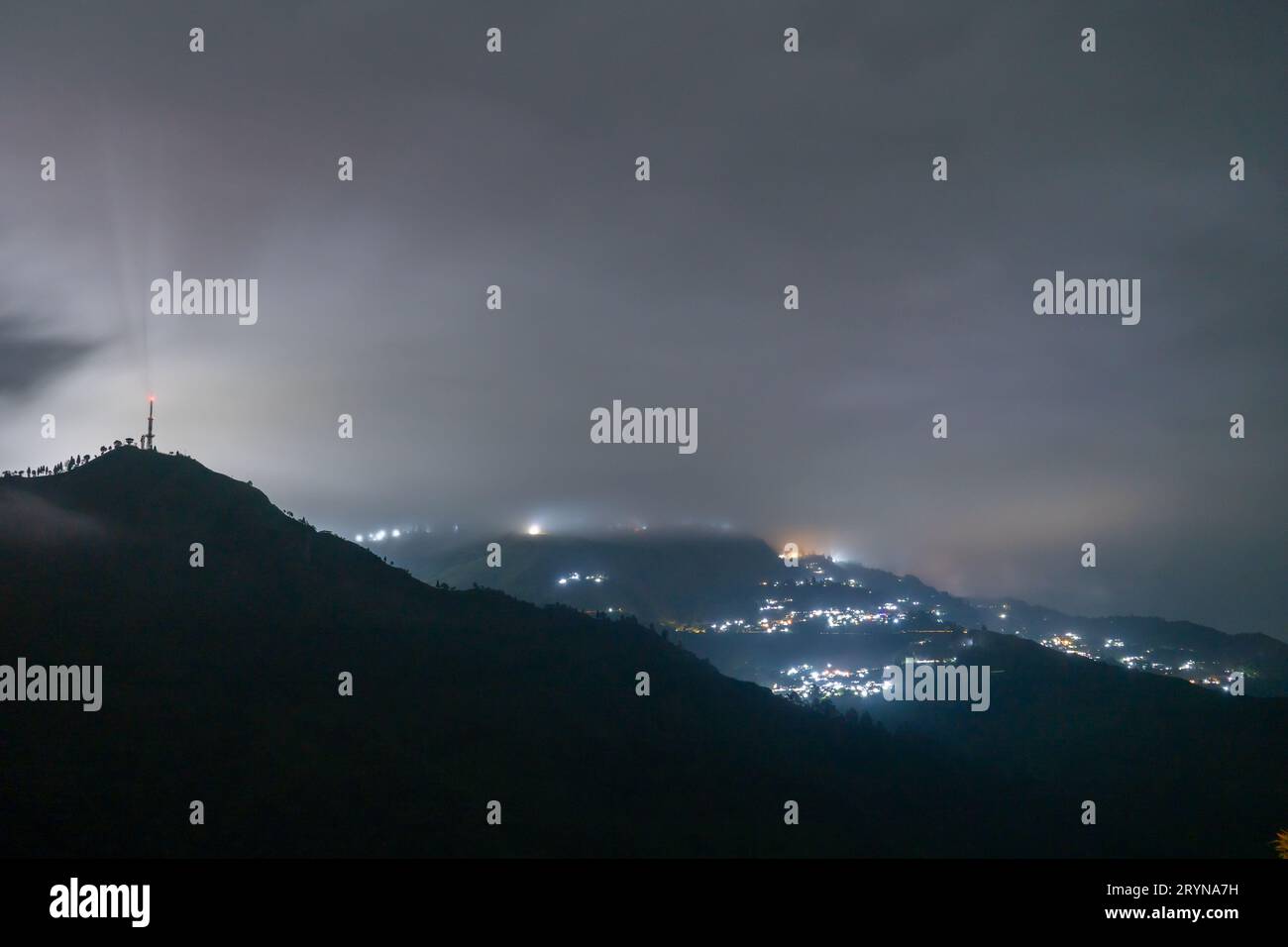 Night long exposure shot showing fog rolling over hills with village in ...