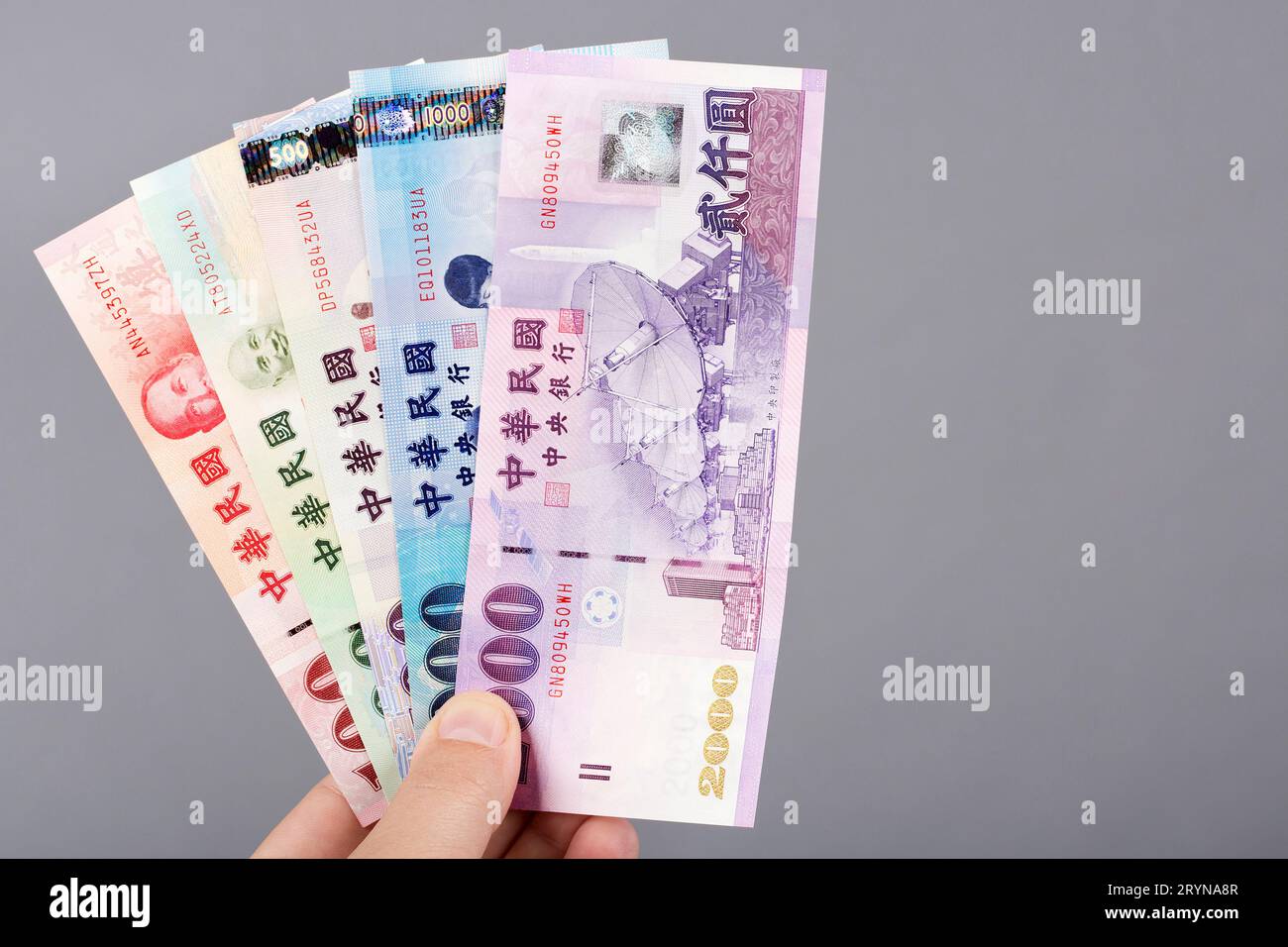 Taiwan money in the hand on a gray background Stock Photo - Alamy