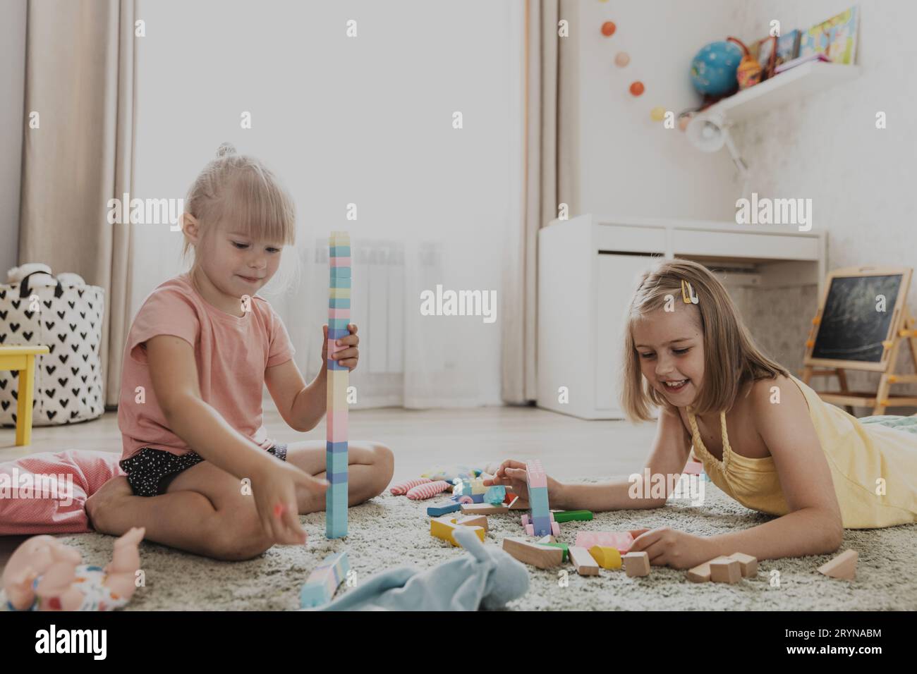 Children playing with colorful toys. Kids sitting on carpet at home ...