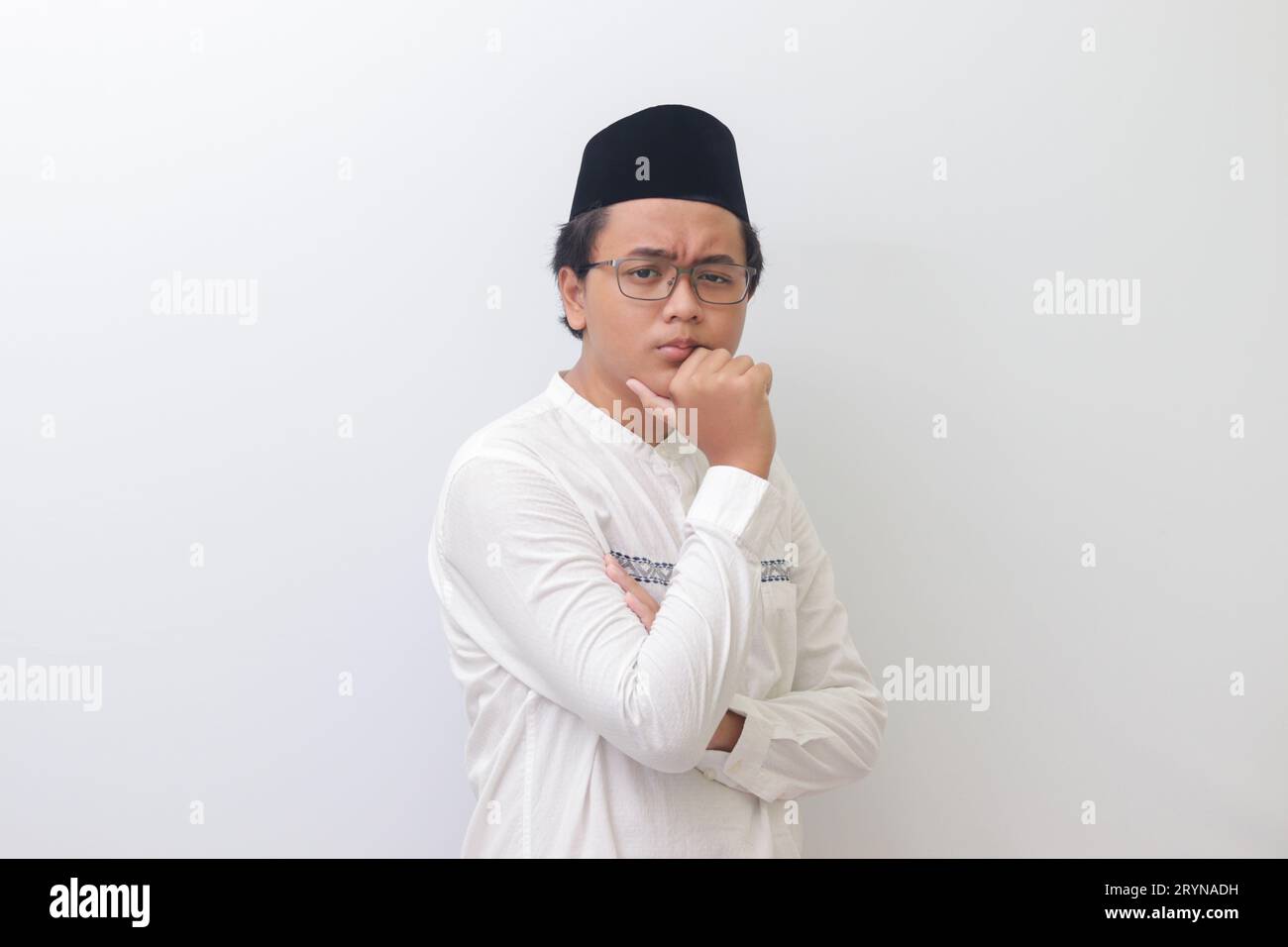 Portrait of young Asian muslim man thinking about question with hand on ...