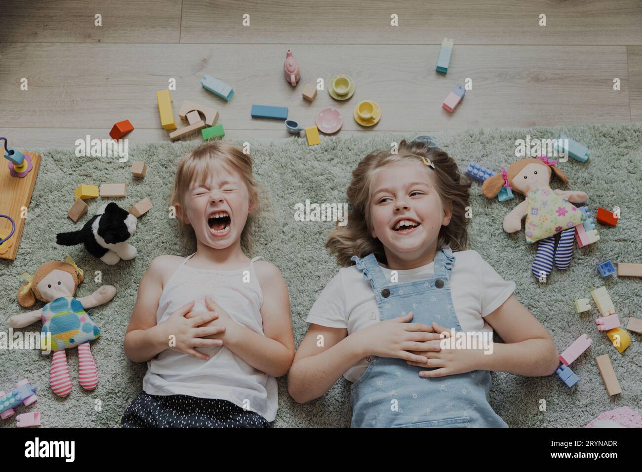 Top view from above on children playing with colorful toys. Portrait of ...
