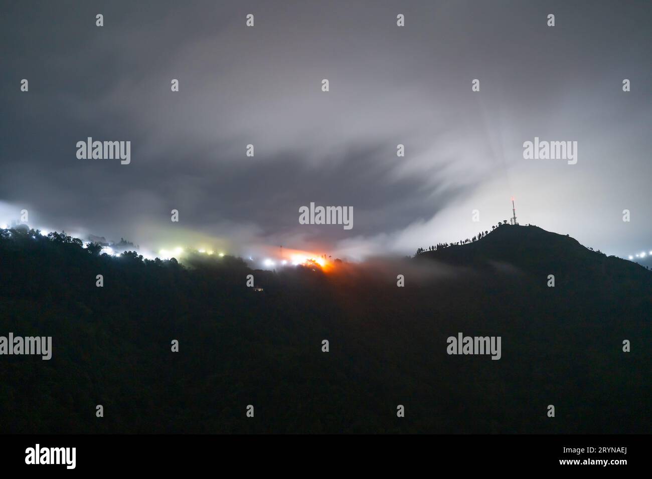Night long exposure shot showing fog and clouds rolling over mountains ...
