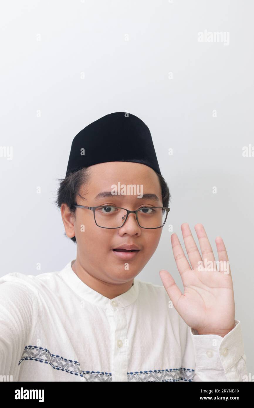 Portrait of smiling young Asian muslim man taking picture of himself or ... Portrait of smiling young Asian muslim man taking picture of himself or ...