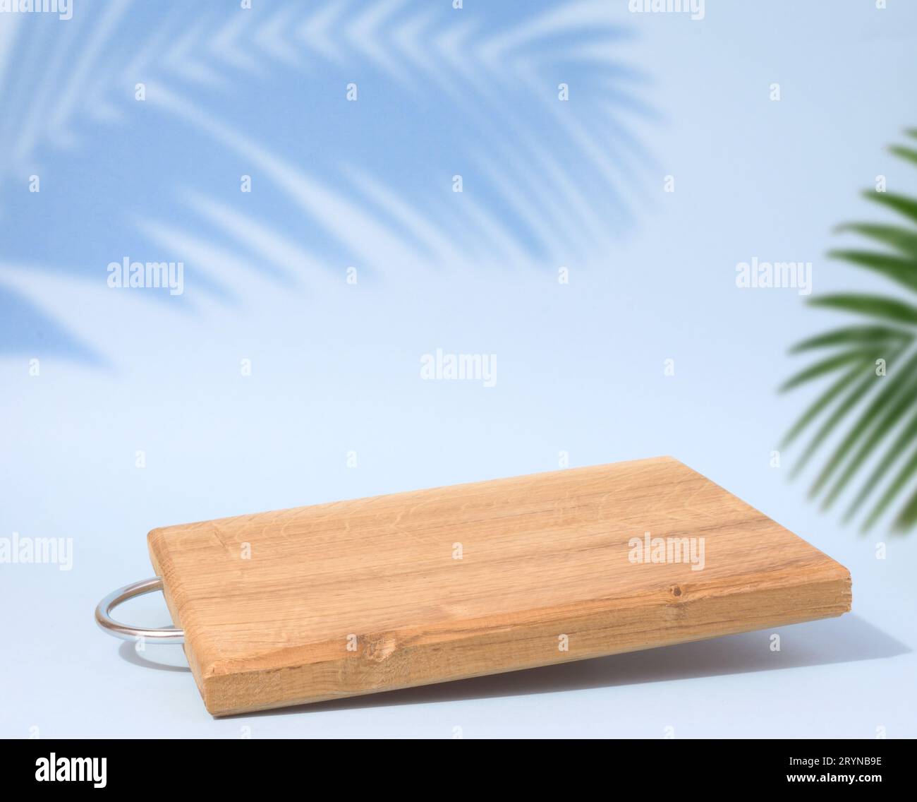 Wooden empty cutting board at an angle on a blue background, kitchen ...