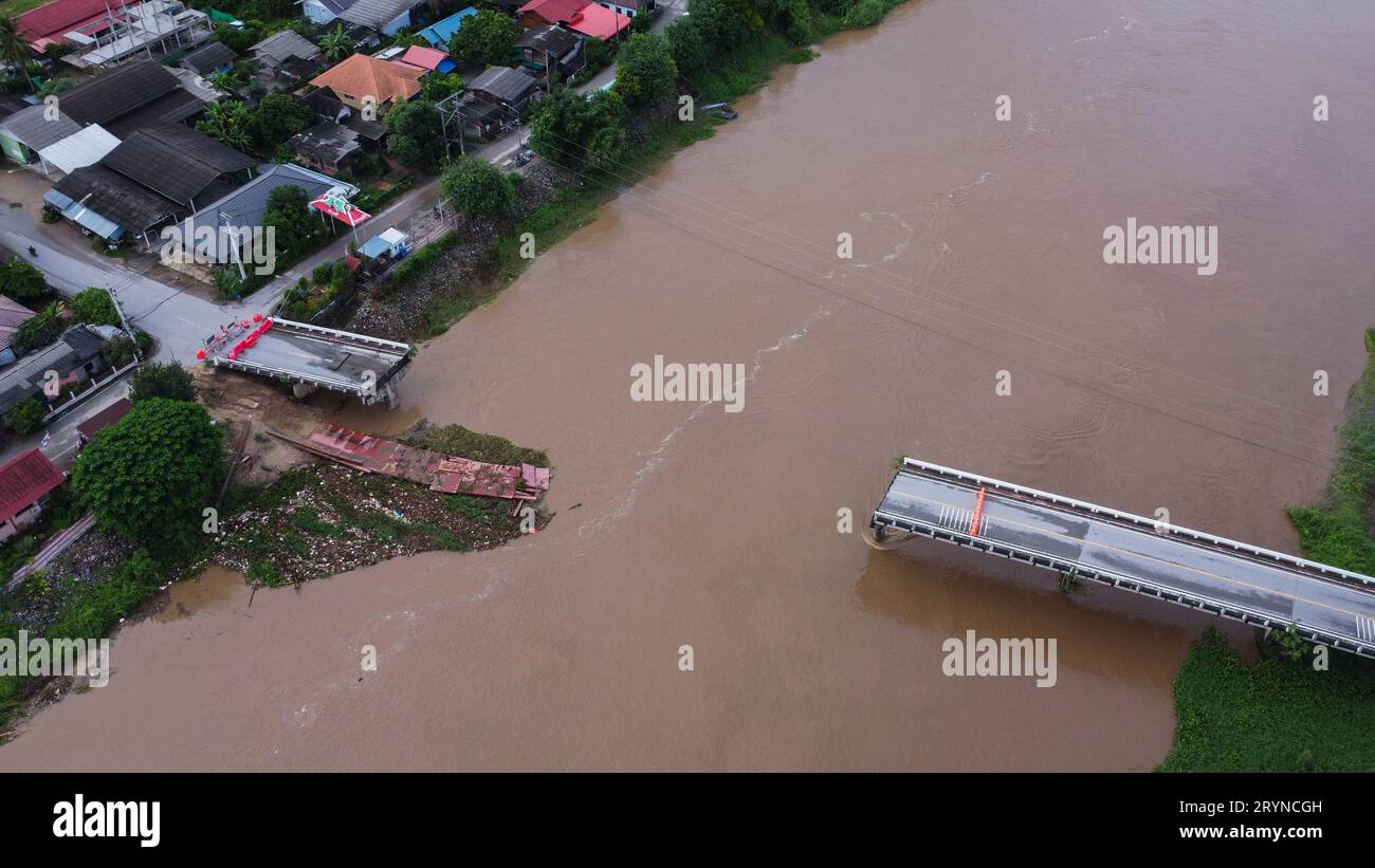 Aerial view of a damaged road bridge over a river after floodwaters washed away the asphalt ...