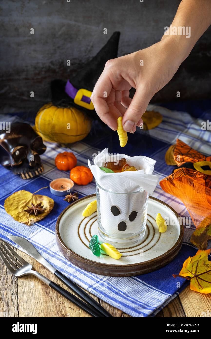 Halloween party. White ghost crafts scary face in glass on a plate and ...