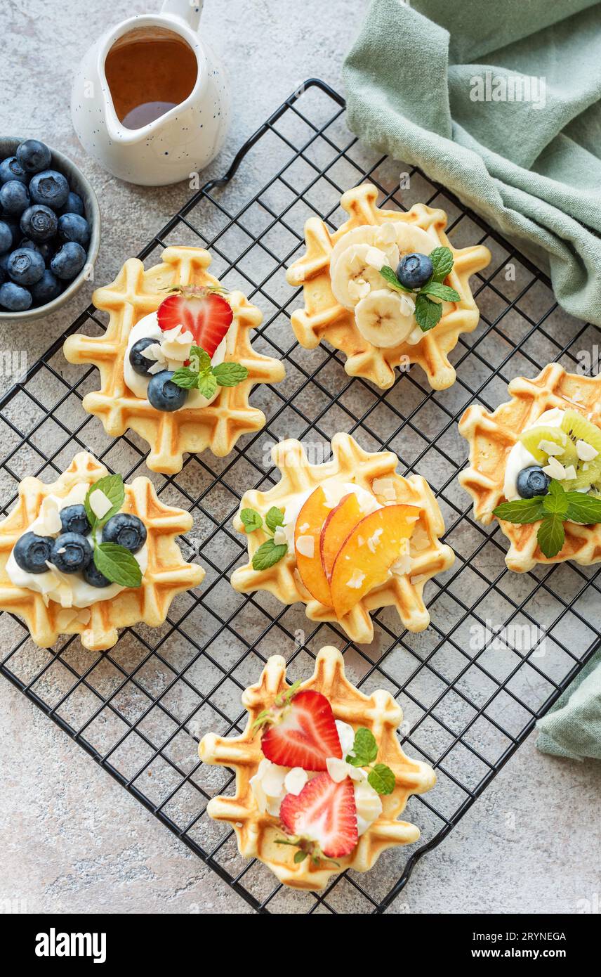 Freshly baked waffles with strawberries and blueberries on a textile ...