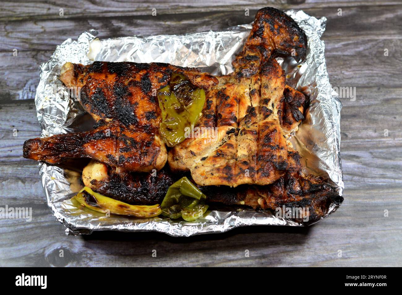 Chicken grilled and roasted on a charcoal grill, served on a disposable ...