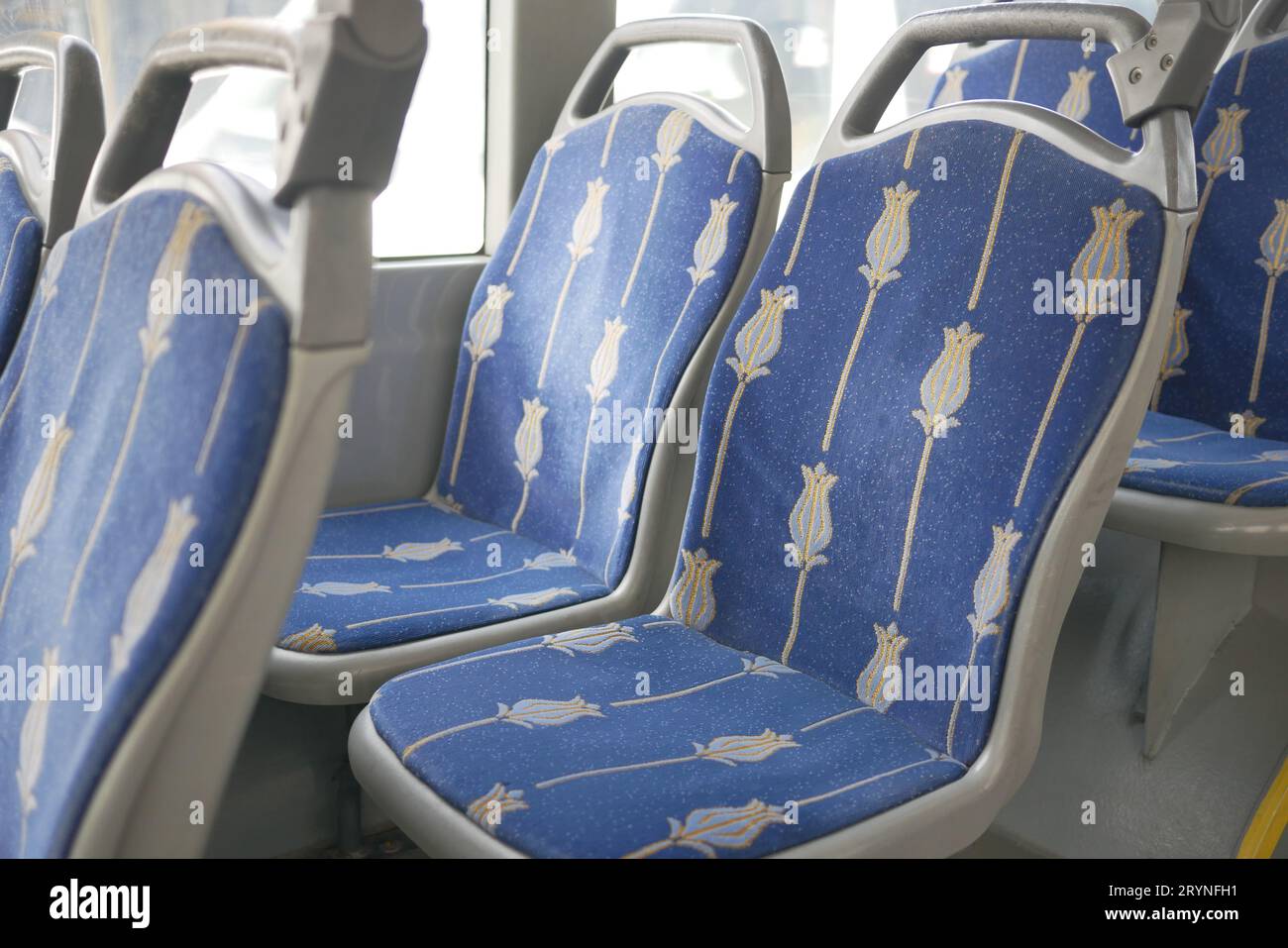 Blue seats inside of empty city bus Stock Photo - Alamy