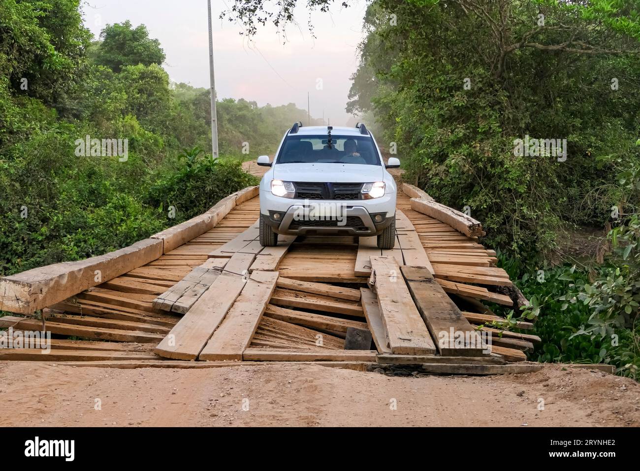 White SUV crossing a run-down wooden bridge on the Transpantaneira road ...
