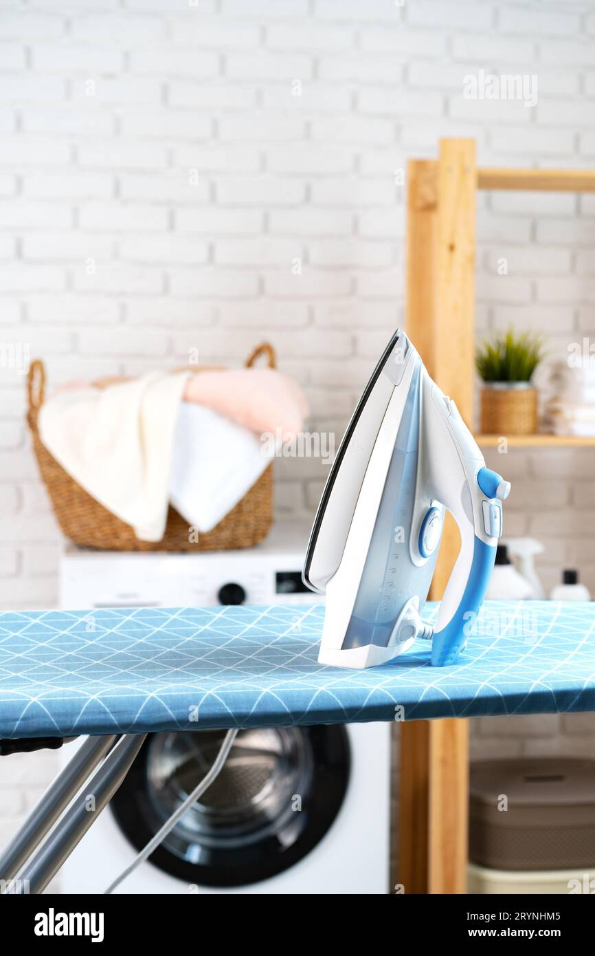 Ironing board at laundry room with washing machine Stock Photo - Alamy