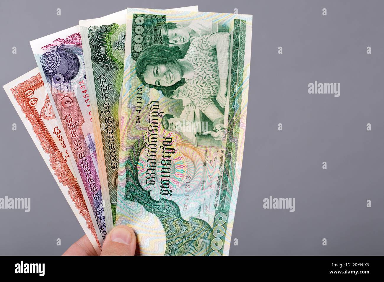 Old Cambodian money in the hand on a gray background Stock Photo - Alamy