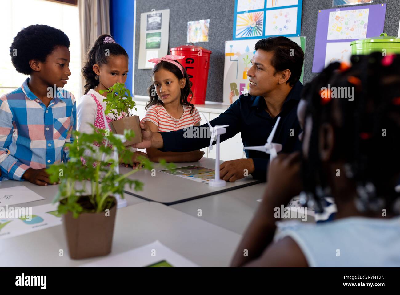 Happy diverse male teacher and children in elementary school class with ...