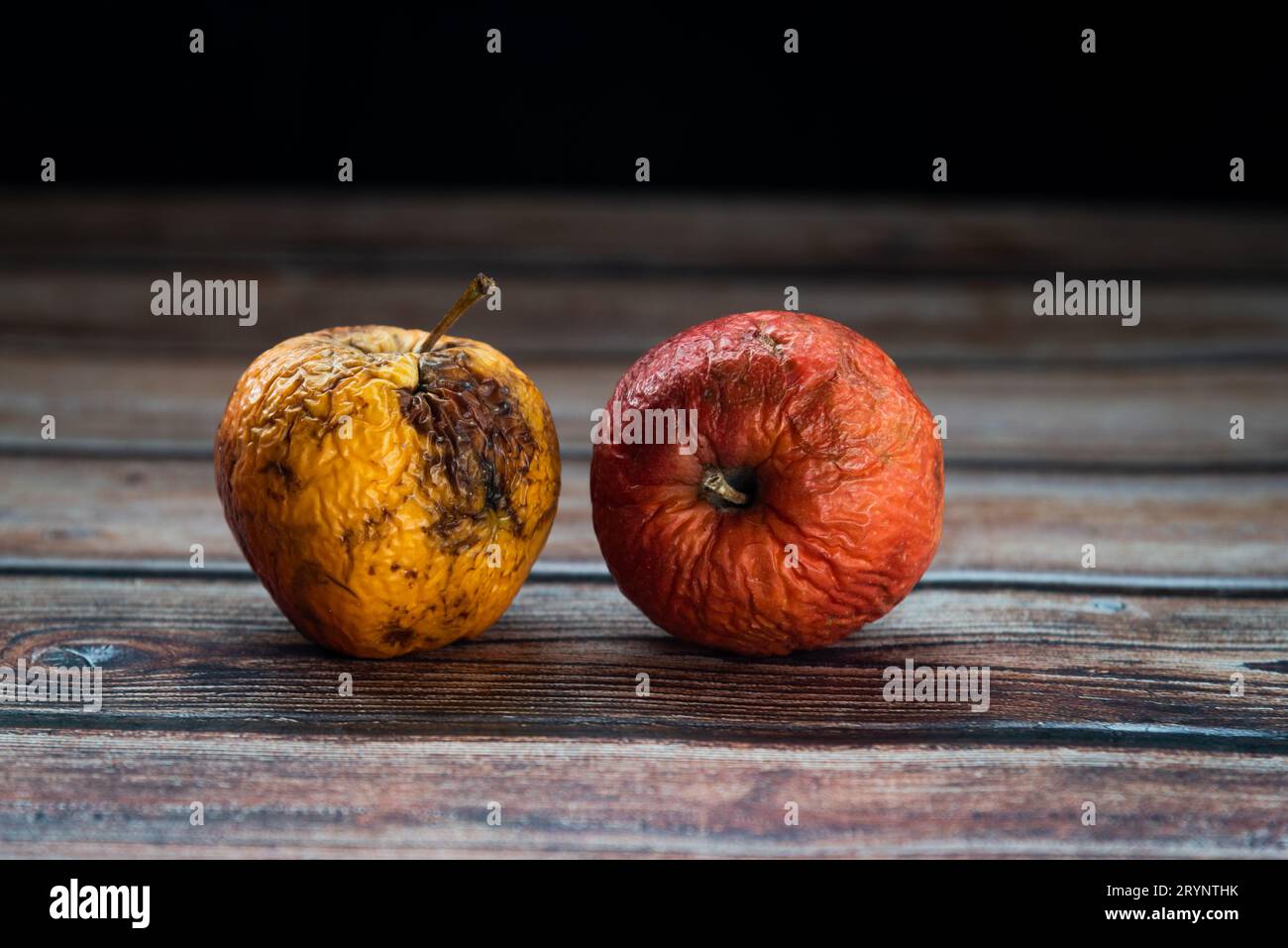 Red wilted rotten apple on a table. Bacteria infected rotten fruit ...