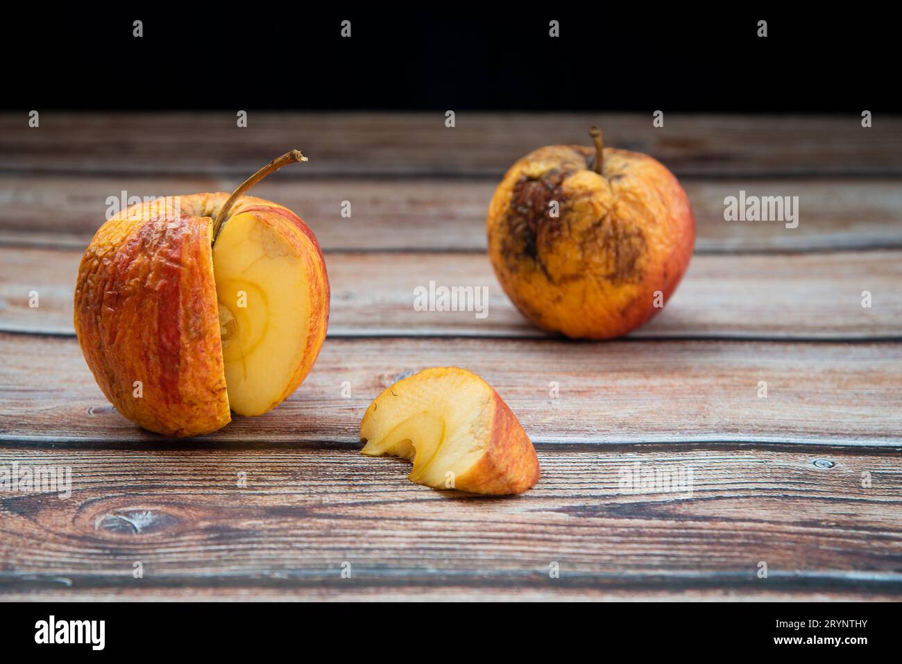 Red wilted rotten apple on a table. Bacteria infected rotten fruit ...