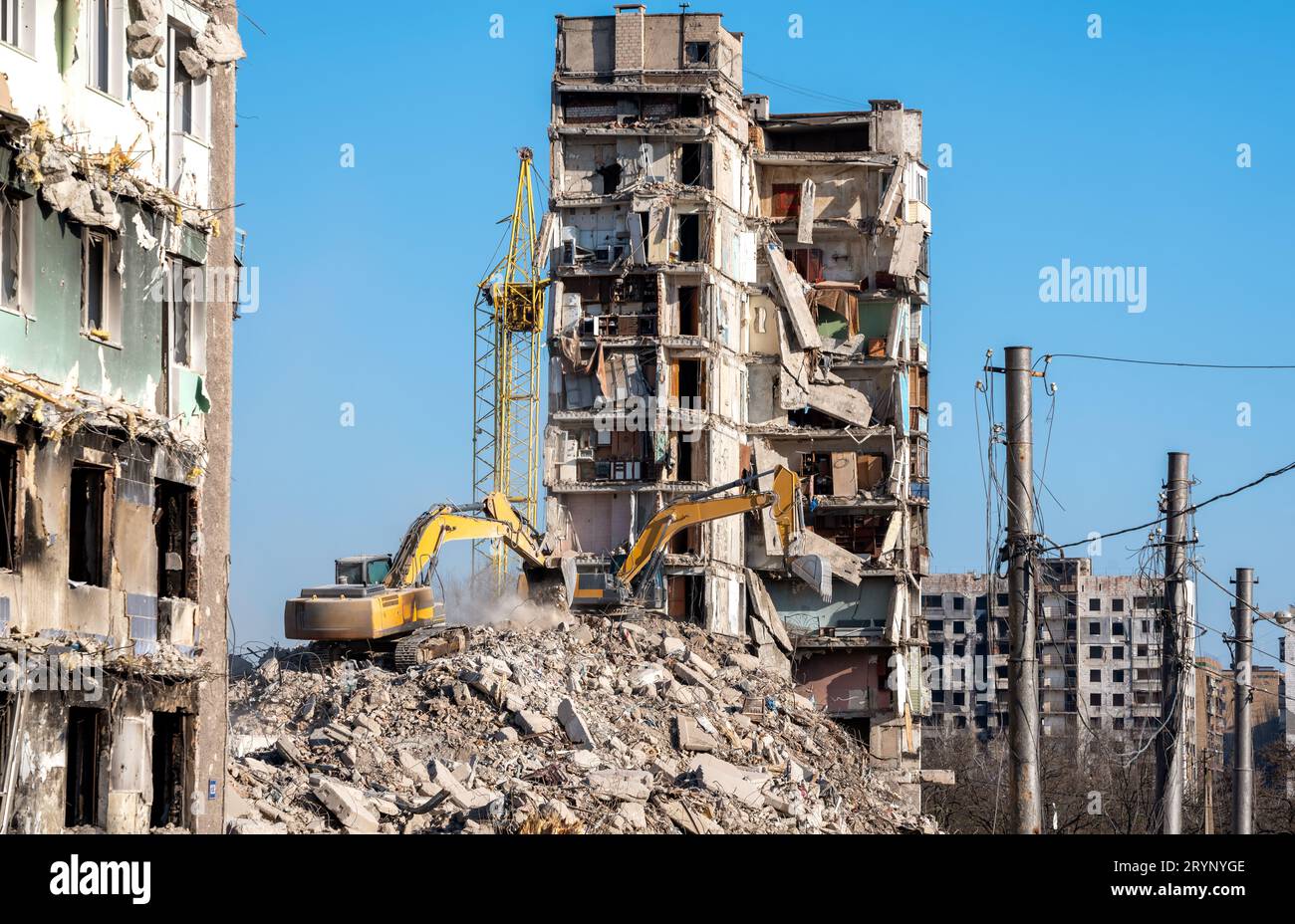 Construction equipment destroys houses damaged during the war in ...