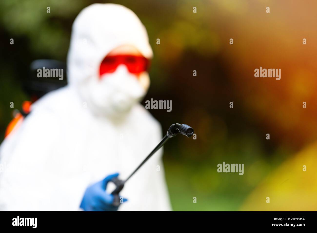 A worker sprays pesticides in an open park. Pest control Stock Photo ...