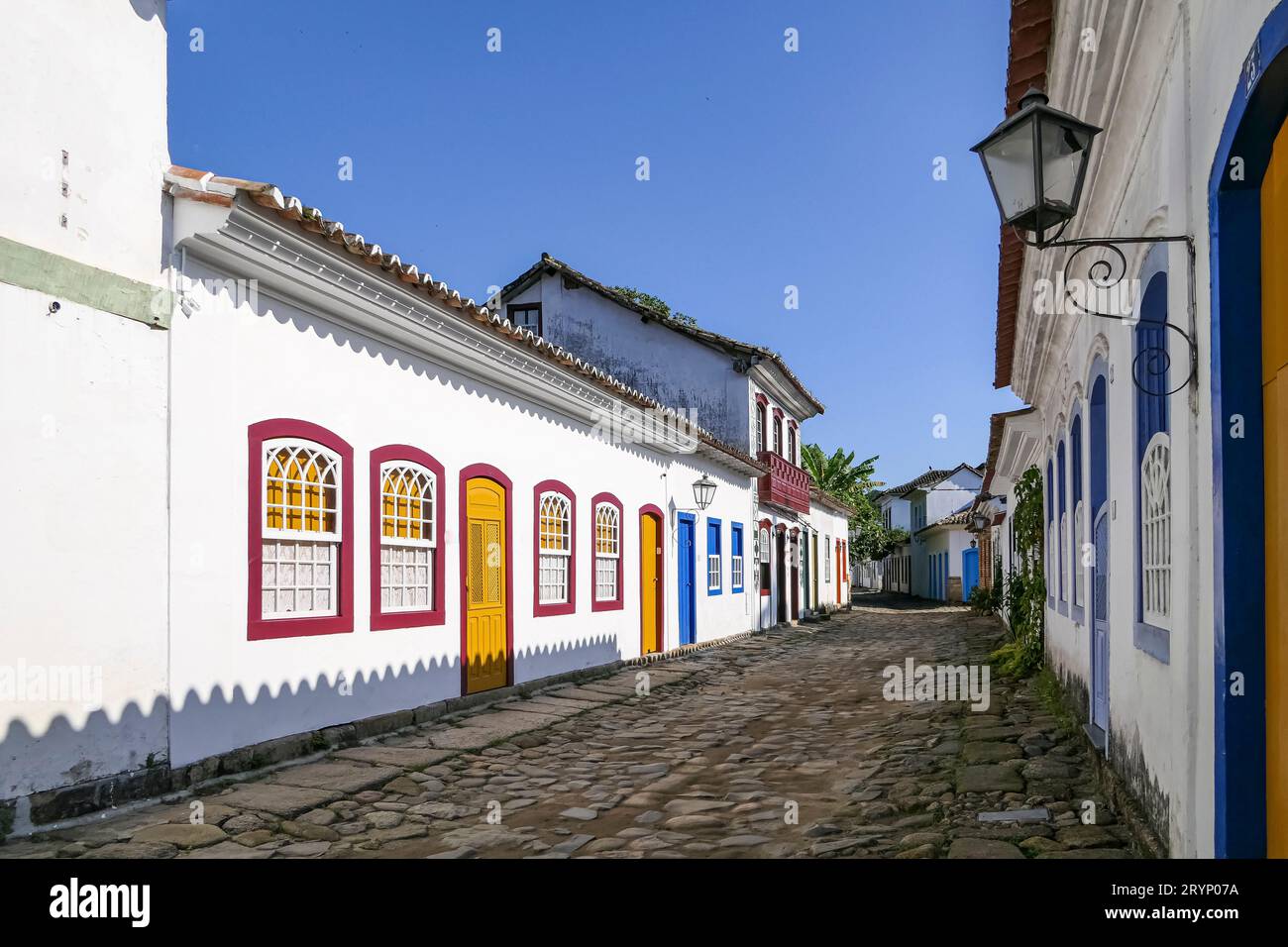 Typical cobblestone street with colonial buildings on a sunny day with ...