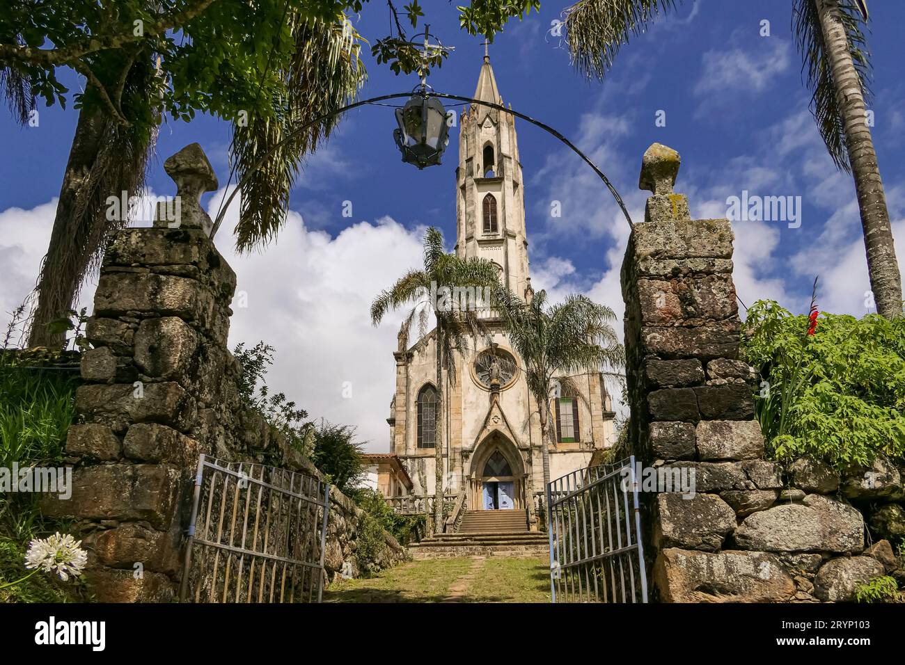View to church through stoney gate, blue sky with white clouds ...