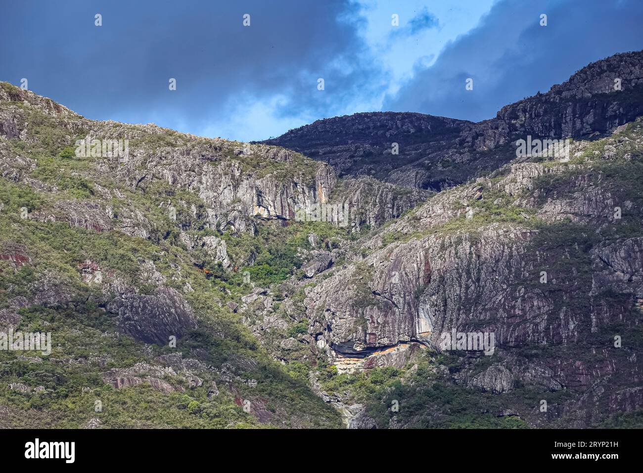 Impressive mountain scenery in sunlight with blue sky and dark clouds ...