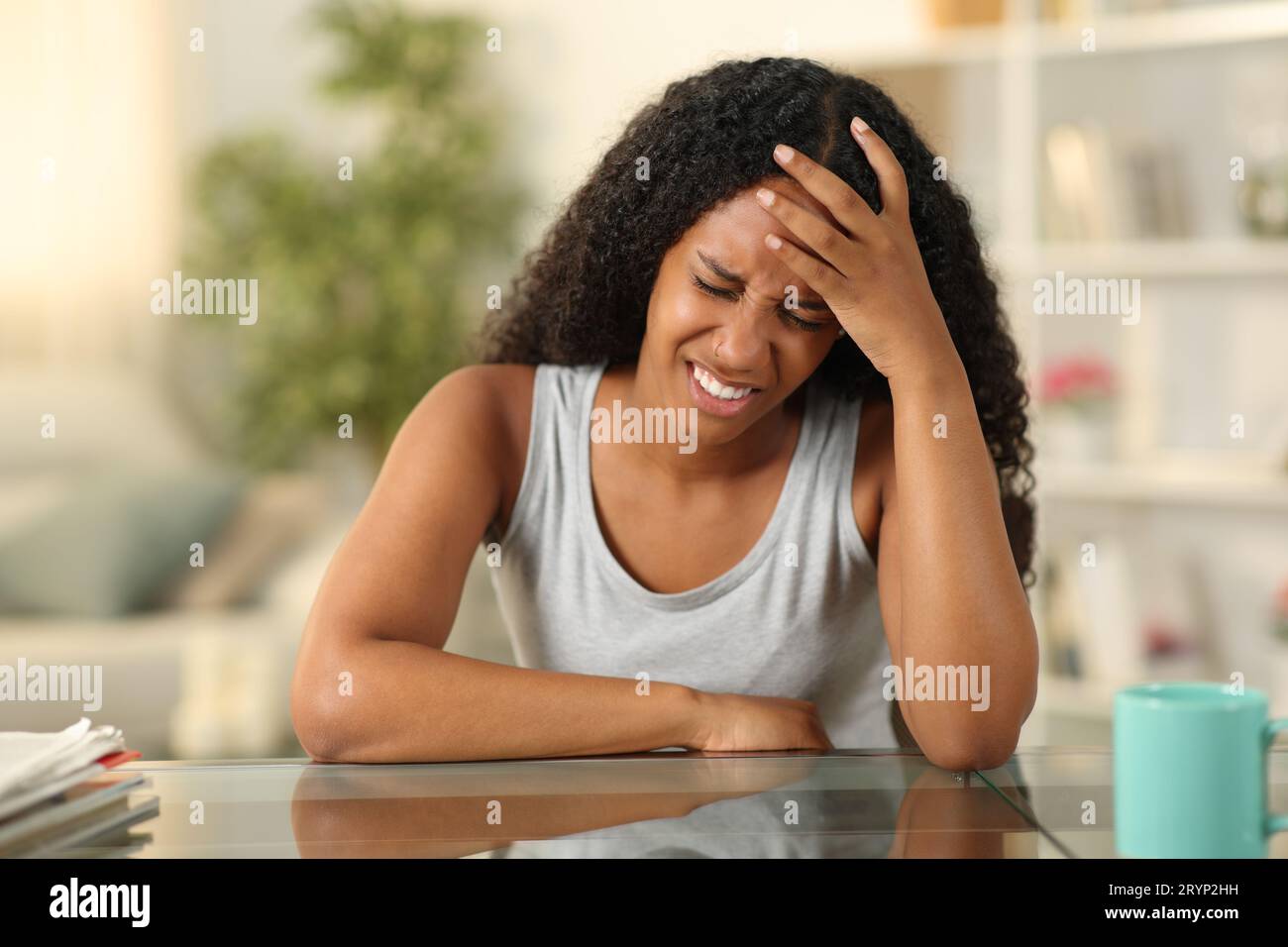 Black woman suffering head ache sitting at home Stock Photo - Alamy