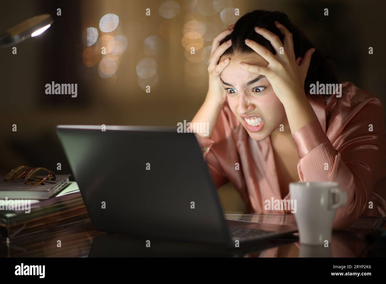Angry tele worker working with laptop in the night at homeoffice Stock ...