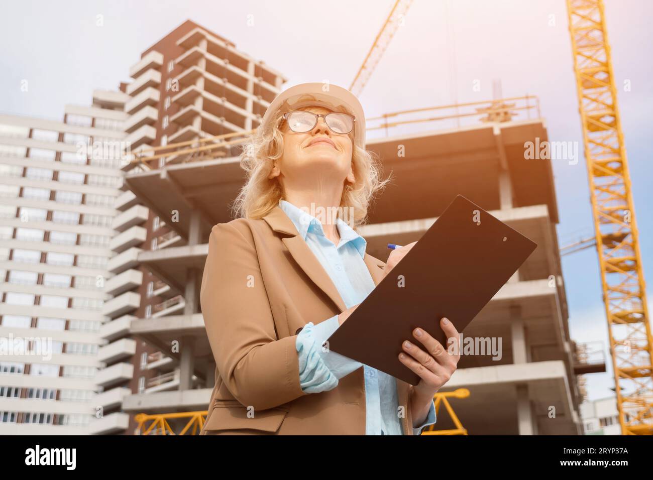 Female architect inspecting work on building construction site Stock ...