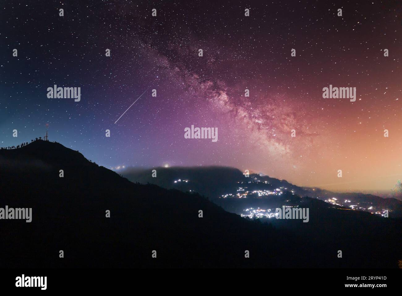 Night long exposure shot showing fog rolling over hills with village in ...