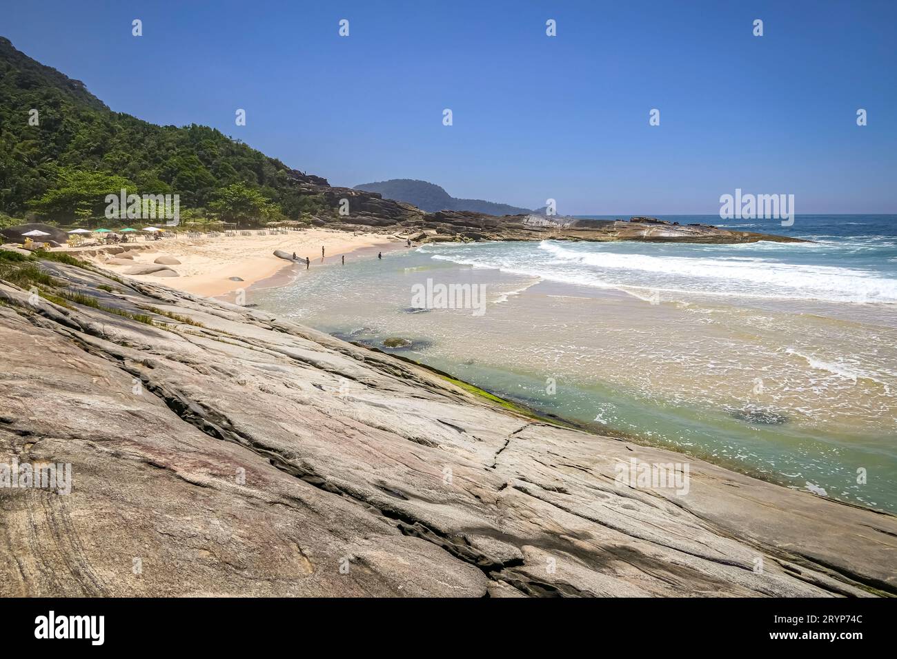 View along mountainous coastline with beach and rock slabs Picinguaba ...
