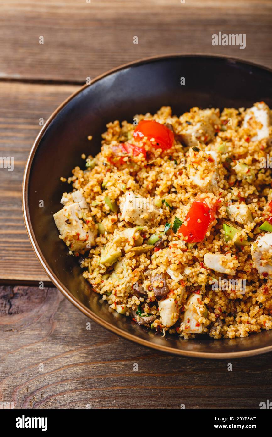 Couscous with turkey, tomatoes, champignon mushrooms and avocado Stock ...