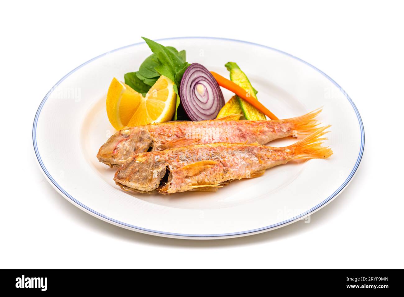 Delicious grilled red mullet fish with garnishes like lemon, greens and ...