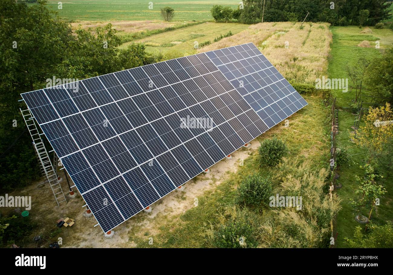 Aerial view of solar panels in green field at daytime. Different types ...