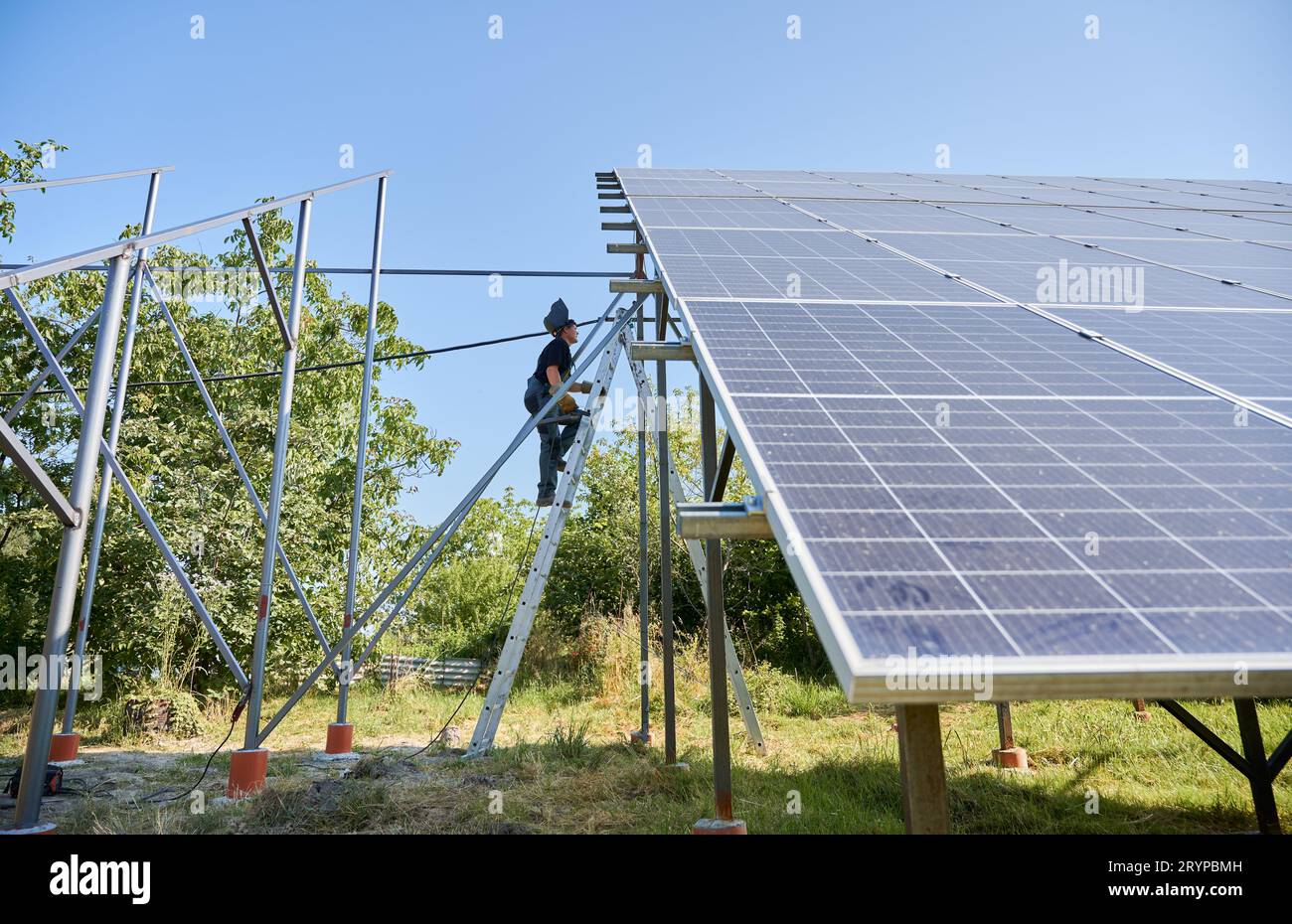 Welder climbing up on staircase for welding. Installing solar panels ...