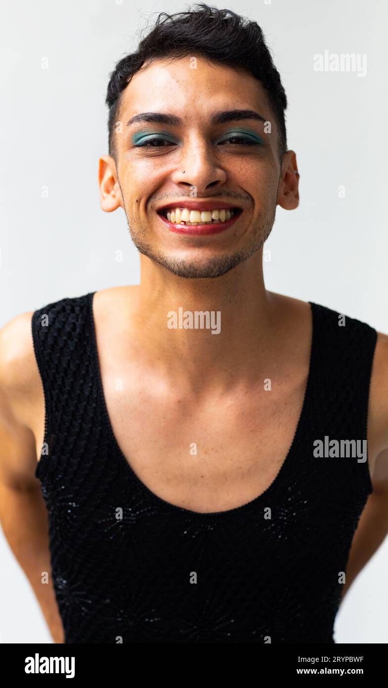 Portrait of happy biracial transgender man wearing make-up, smiling on ...