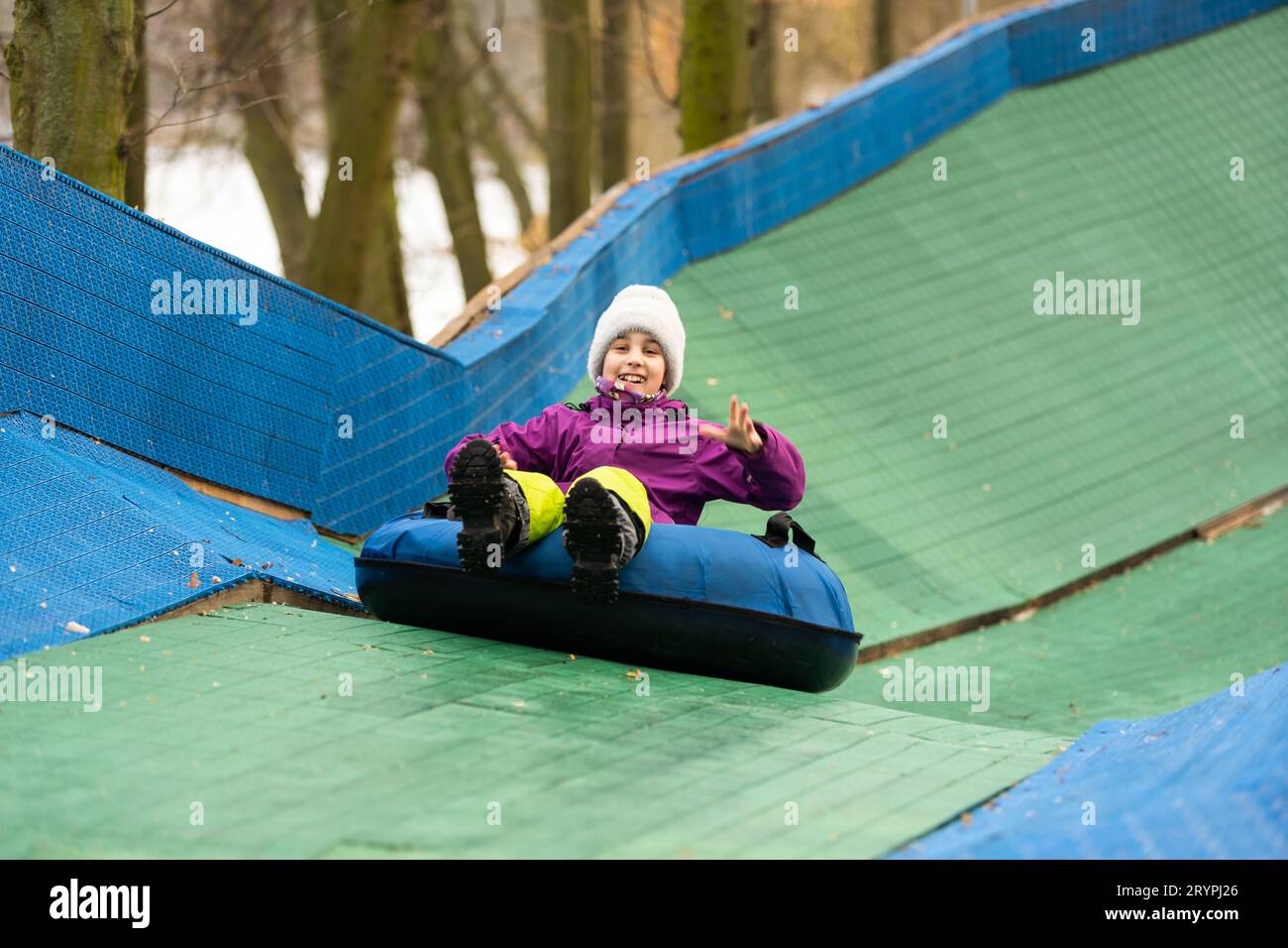 a little kid enjoying tubing down the wavy track ski resort Stock Photo ...