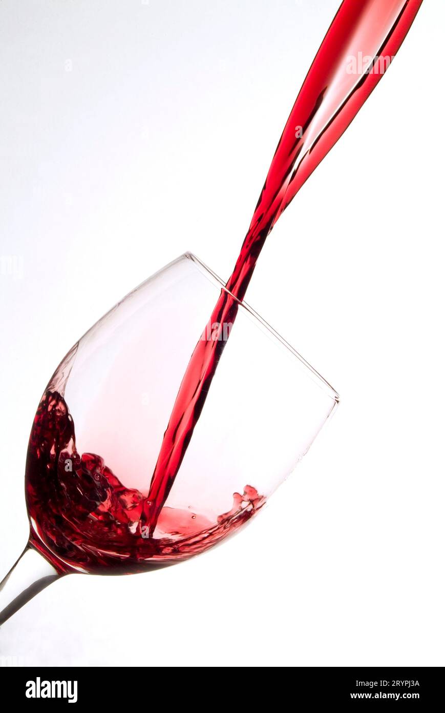 Red wine splashing into a tilted wine glass Stock Photo - Alamy