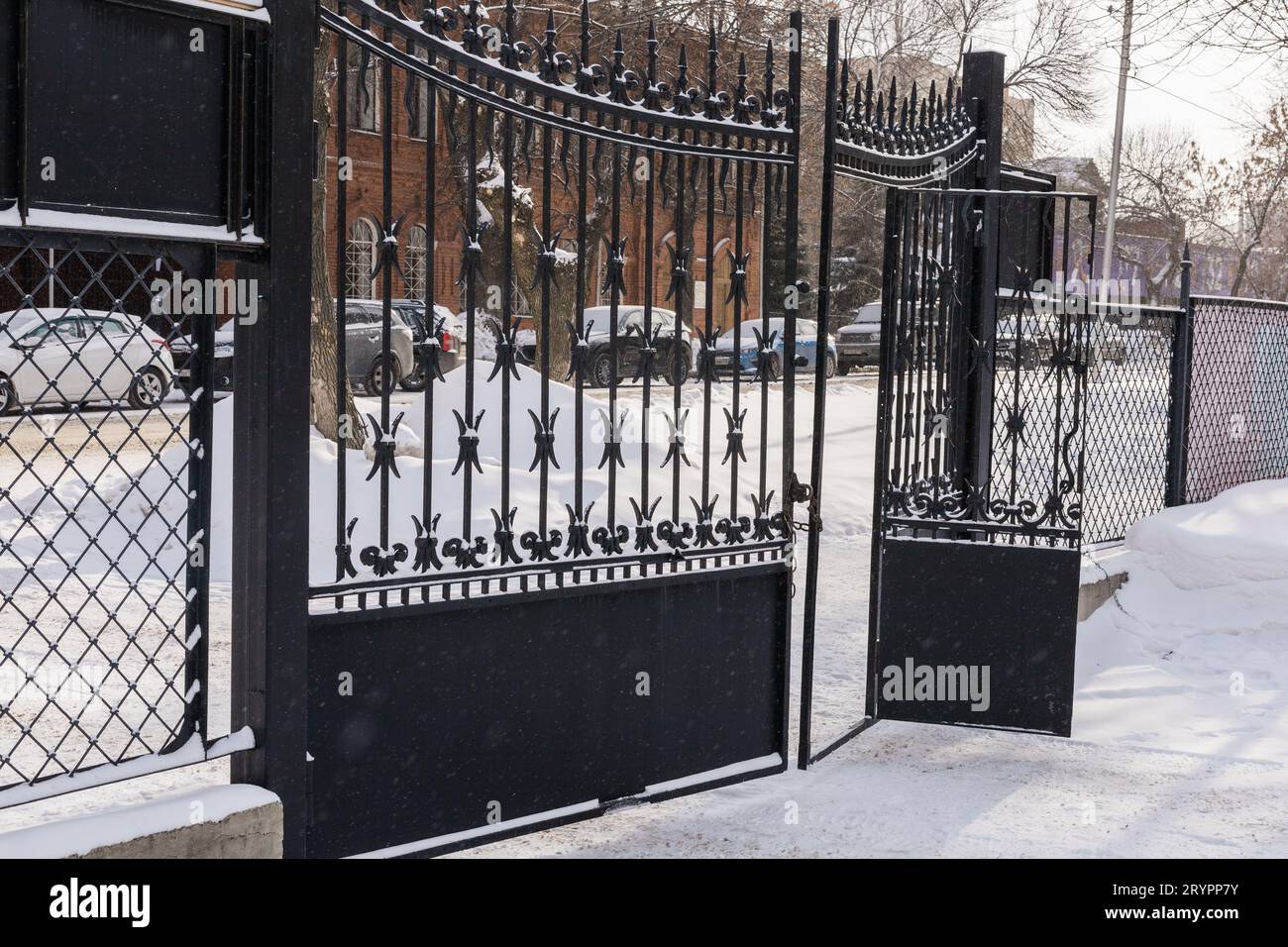 Old iron gate with ironwork unlocked with snowy scene falling and snow ...