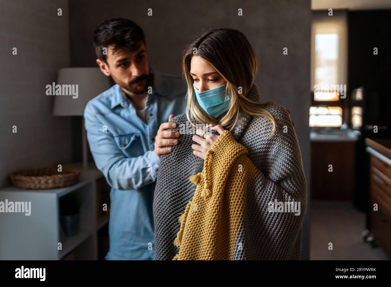 Young woman suffering with cold and flu, cancer. Husband taking care of ...
