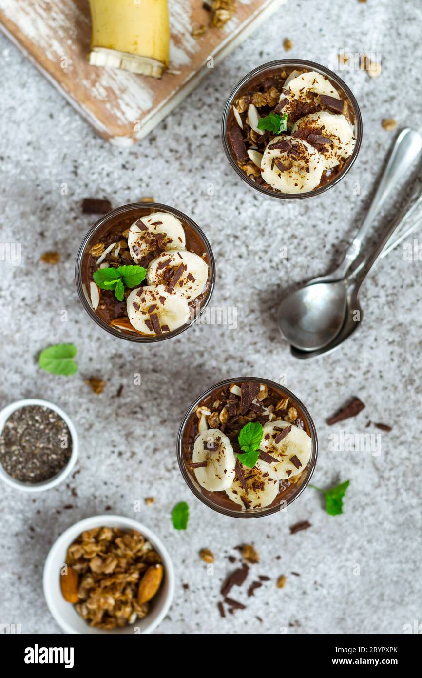 Chocolate pudding with chia and banana in glasses. Healthy dessert or ...