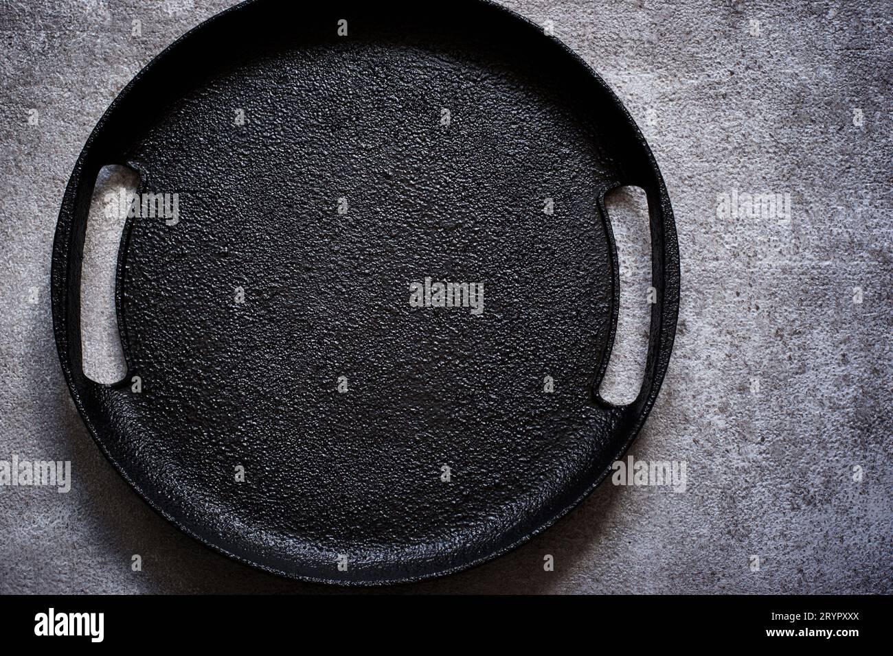 Empty rustic black cast iron plate On a concrete background. Top Stock ...