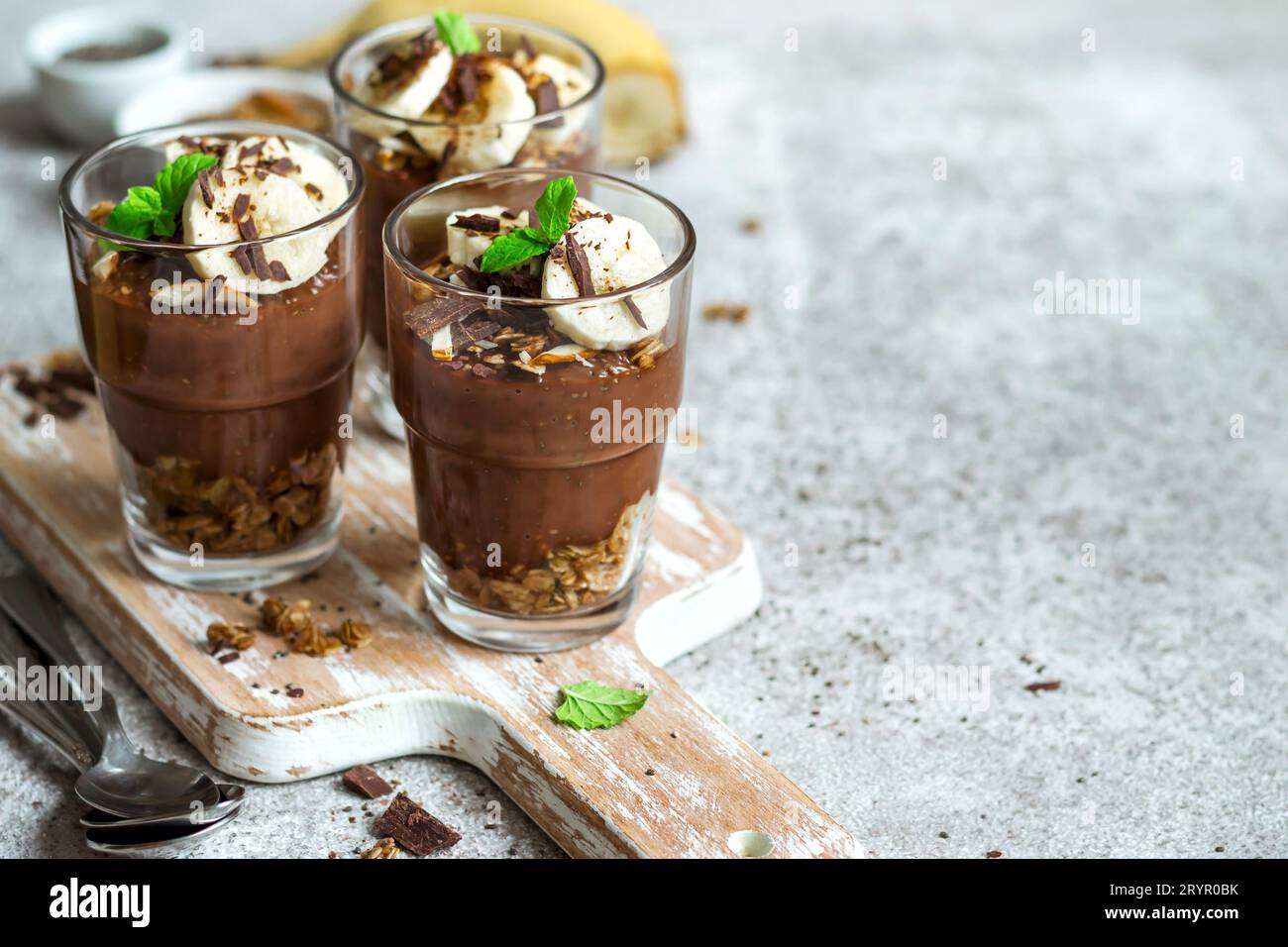 Chocolate pudding with chia and banana in glasses. Healthy dessert or ...