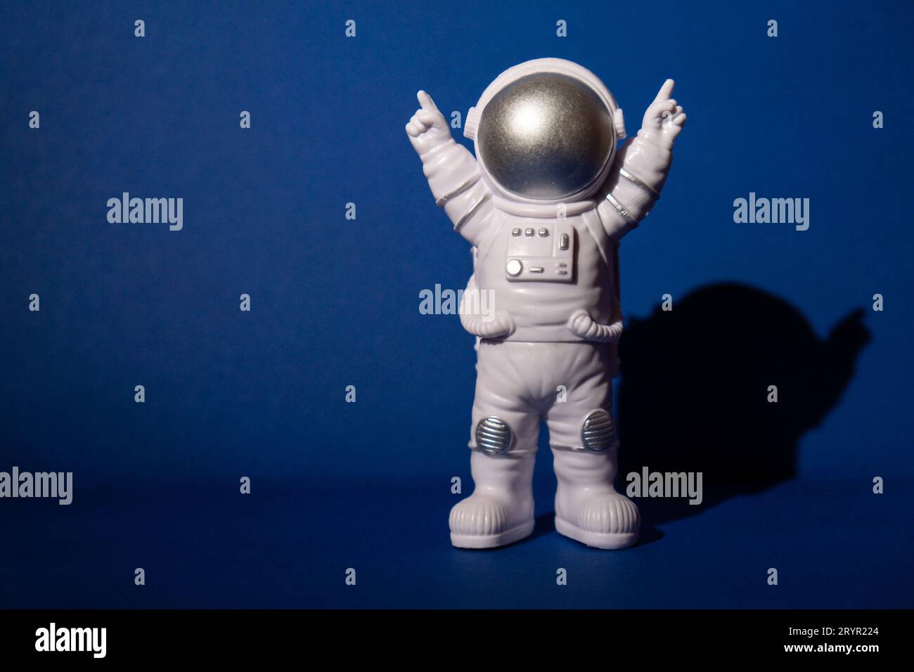 Plastic toy astronaut on colorful blue background Copy space. Concept ...