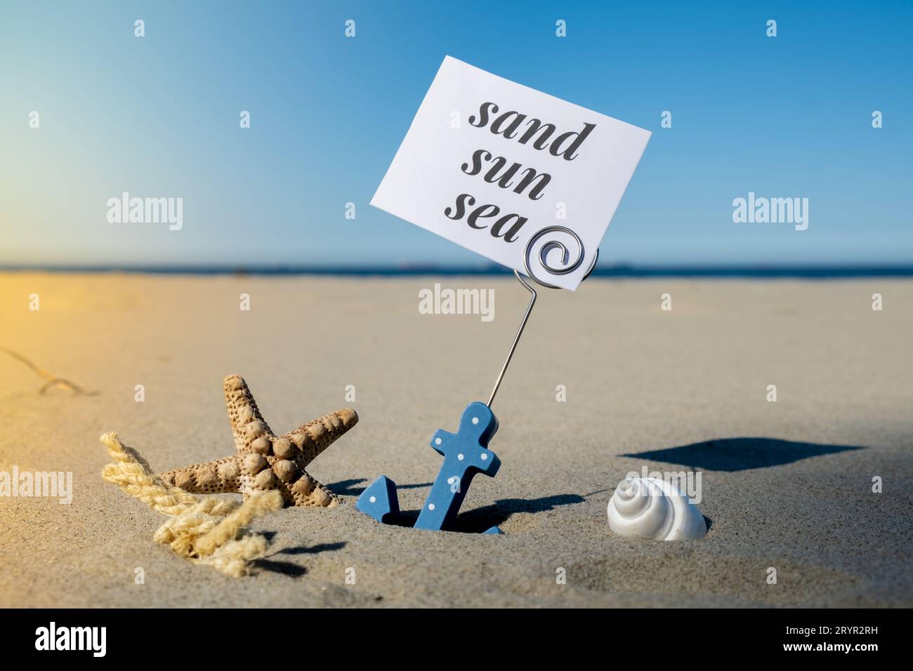 SAND SUN SEA text on paper greeting card in anchor paper holder and ...