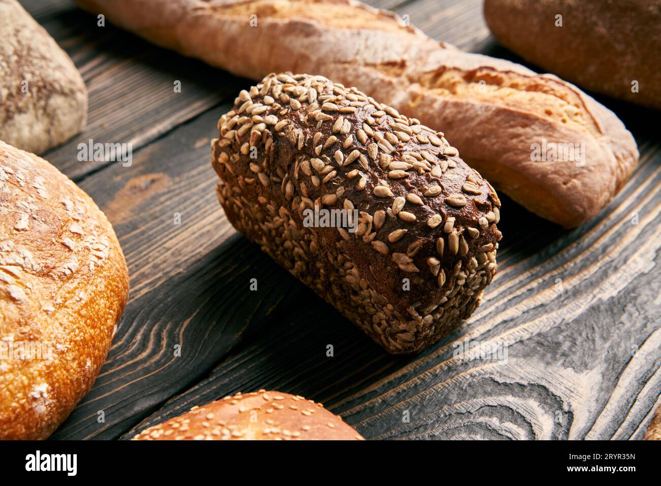Different types of bread loaves on dark wooden background Stock Photo ...