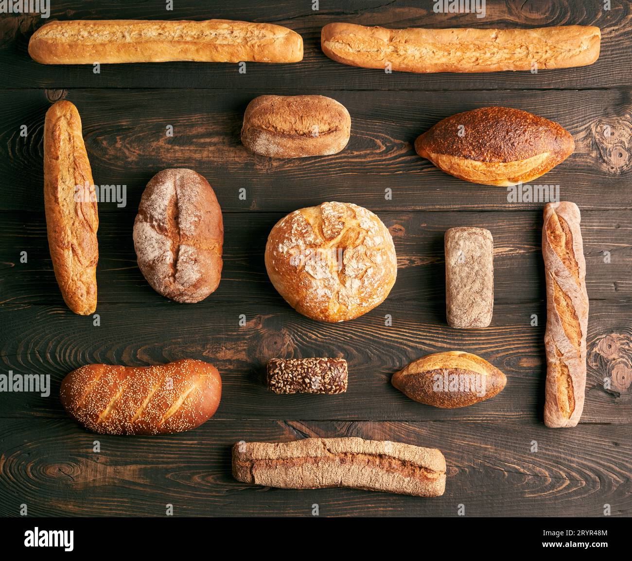 Different types of bread loaves on dark wooden background Stock Photo ...