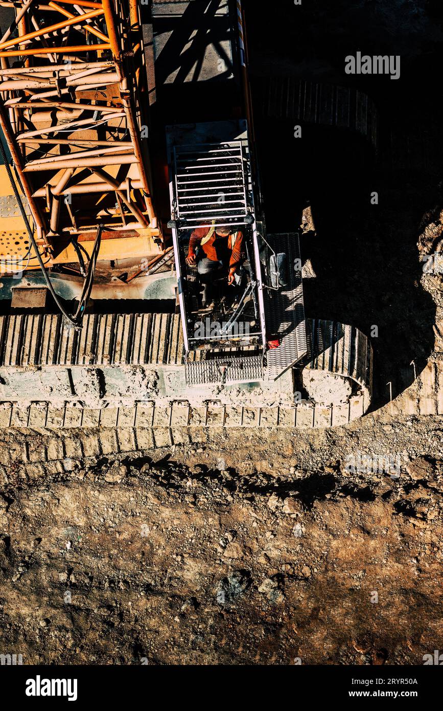 High perspective view of man inside a large crane machinery in a ...